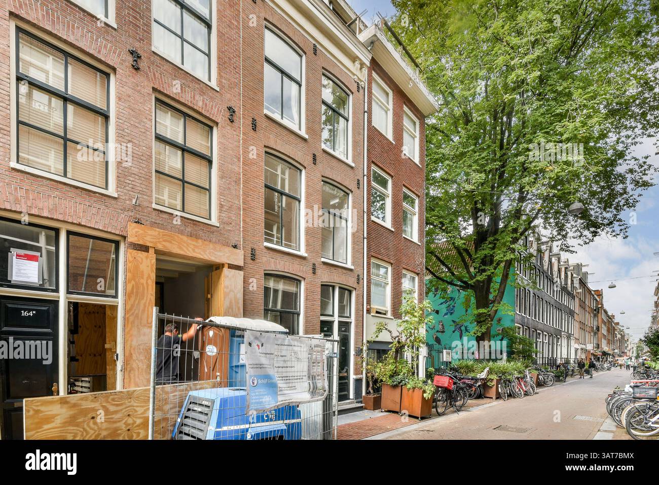 Colorful brick buildings line a quaint street, interspersed with lush ...