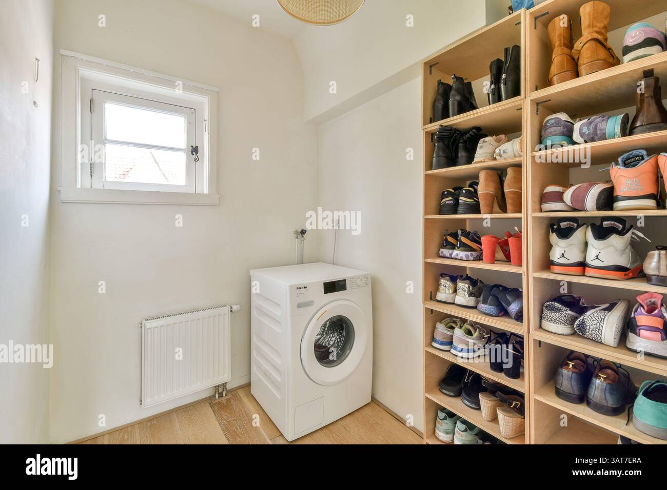 A bright laundry room featuring a washing machine and organized shoe ...