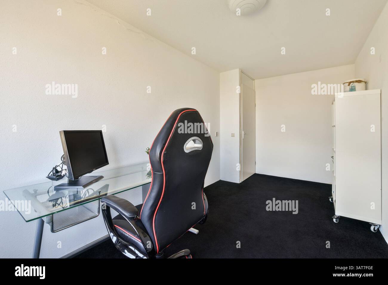 A sleek and minimalistic office space featuring a glass desk, a ...