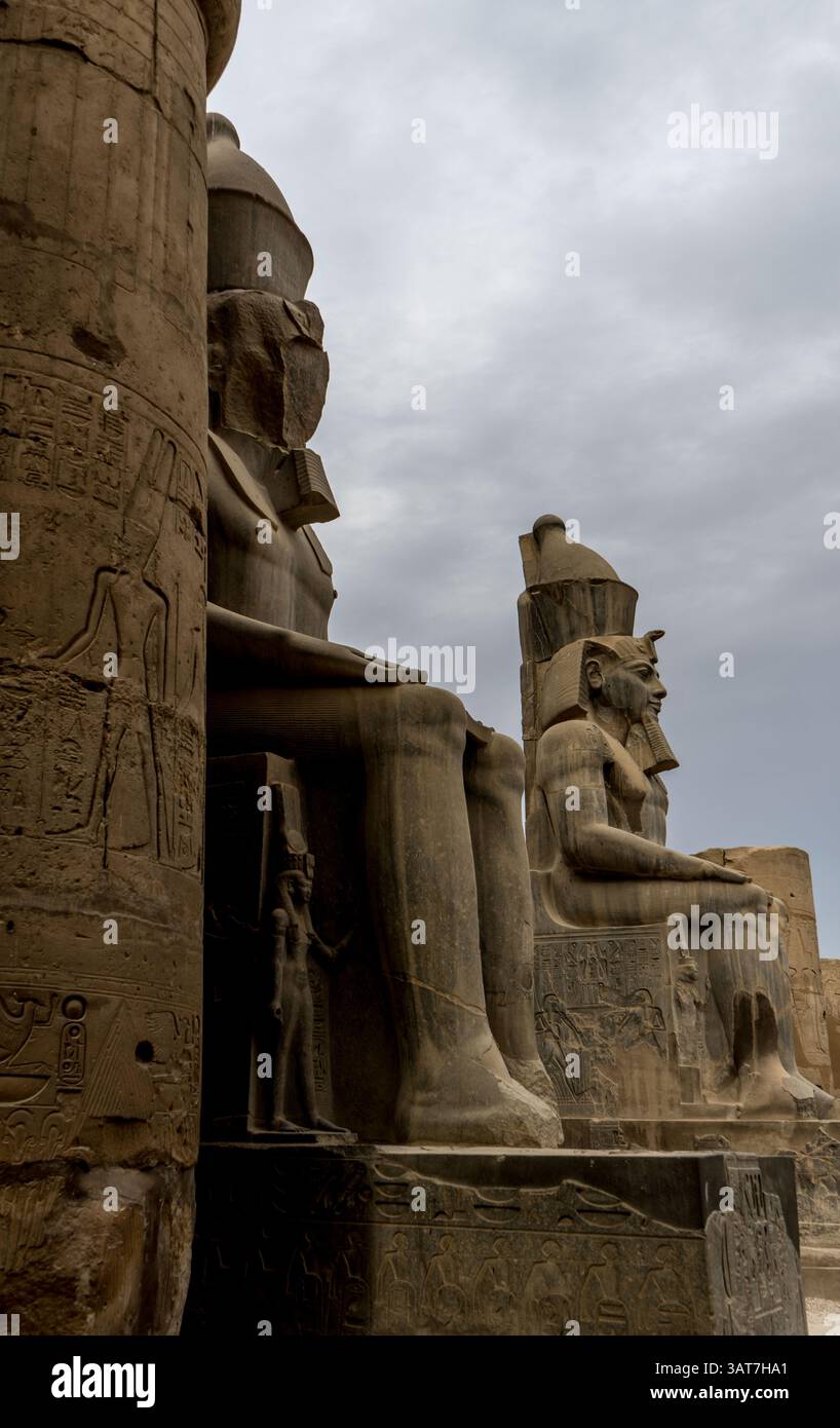 Ancient Egyptian statues of pharaohs seated beside intricately carved ...