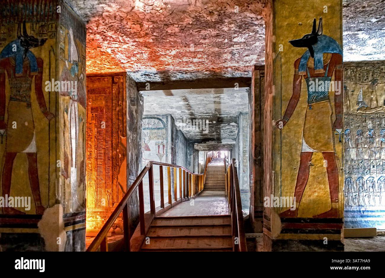An ancient Egyptian tomb interior featuring colorful hieroglyphs and murals. The walls are ...