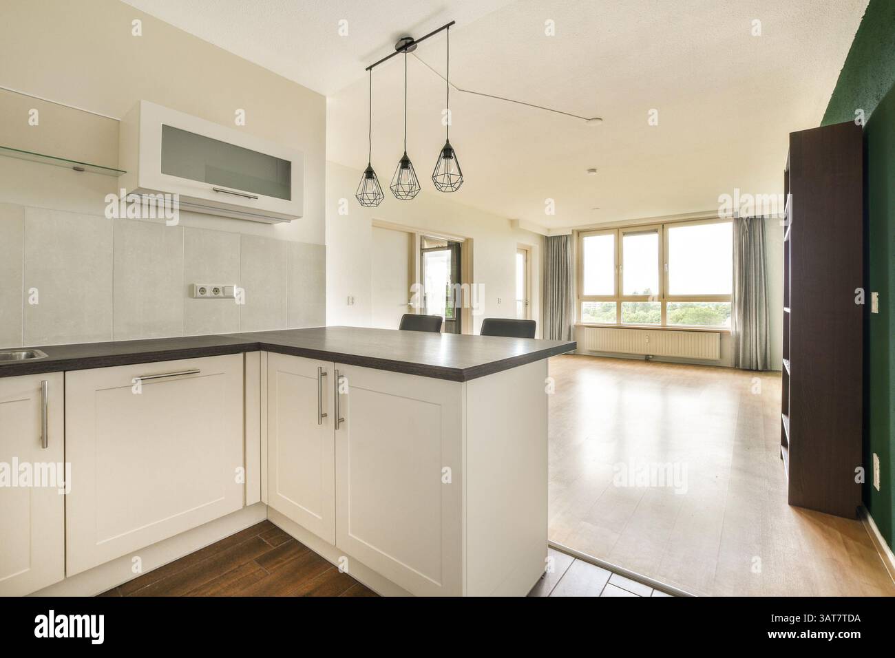 A stylish kitchen featuring sleek cabinetry, contemporary lighting, and ...