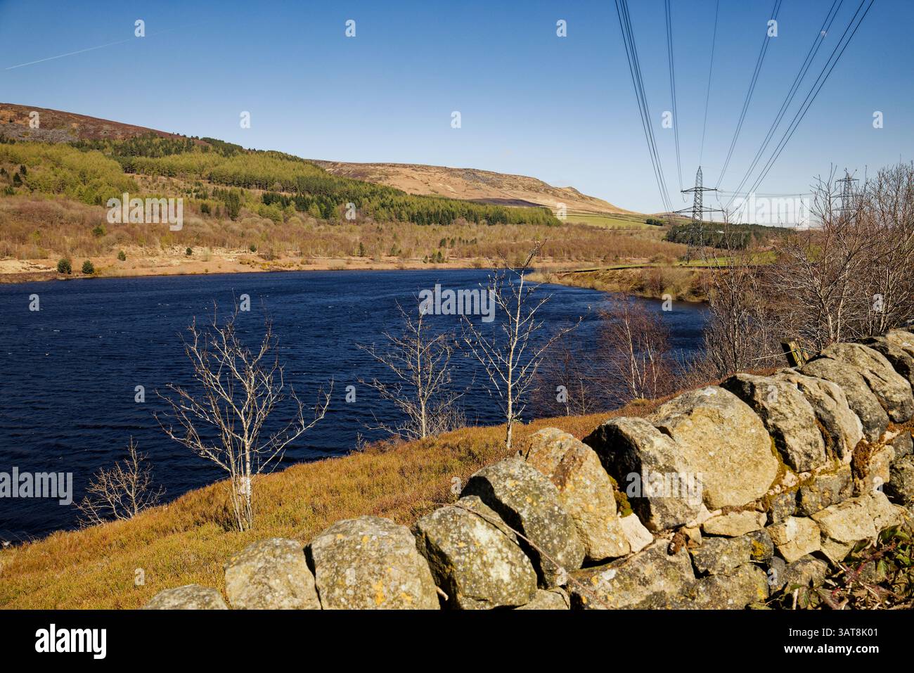 Electricity transmission lines stretch across the blue waters of ...