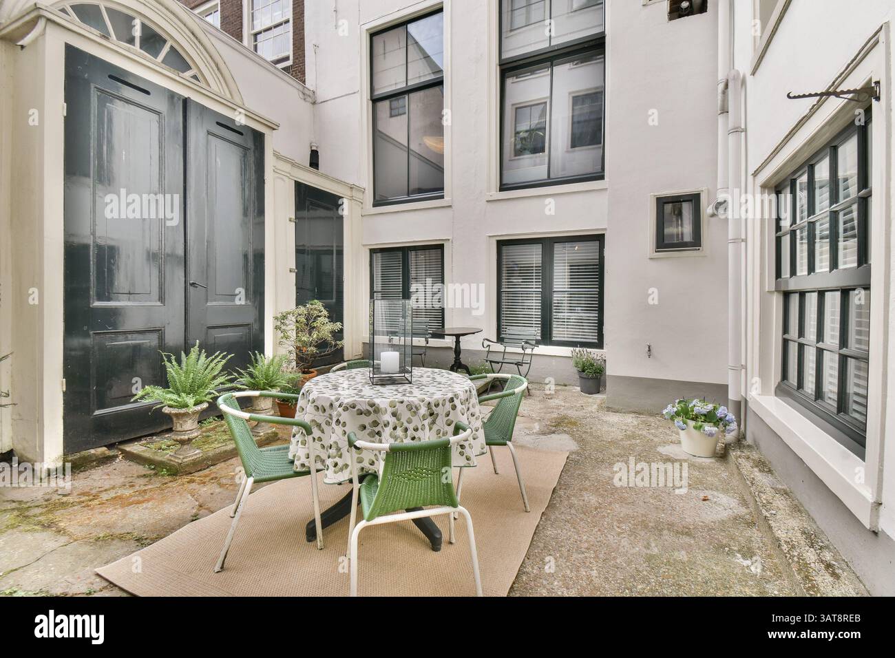 An inviting outdoor cafe area featuring a round table surrounded by ...