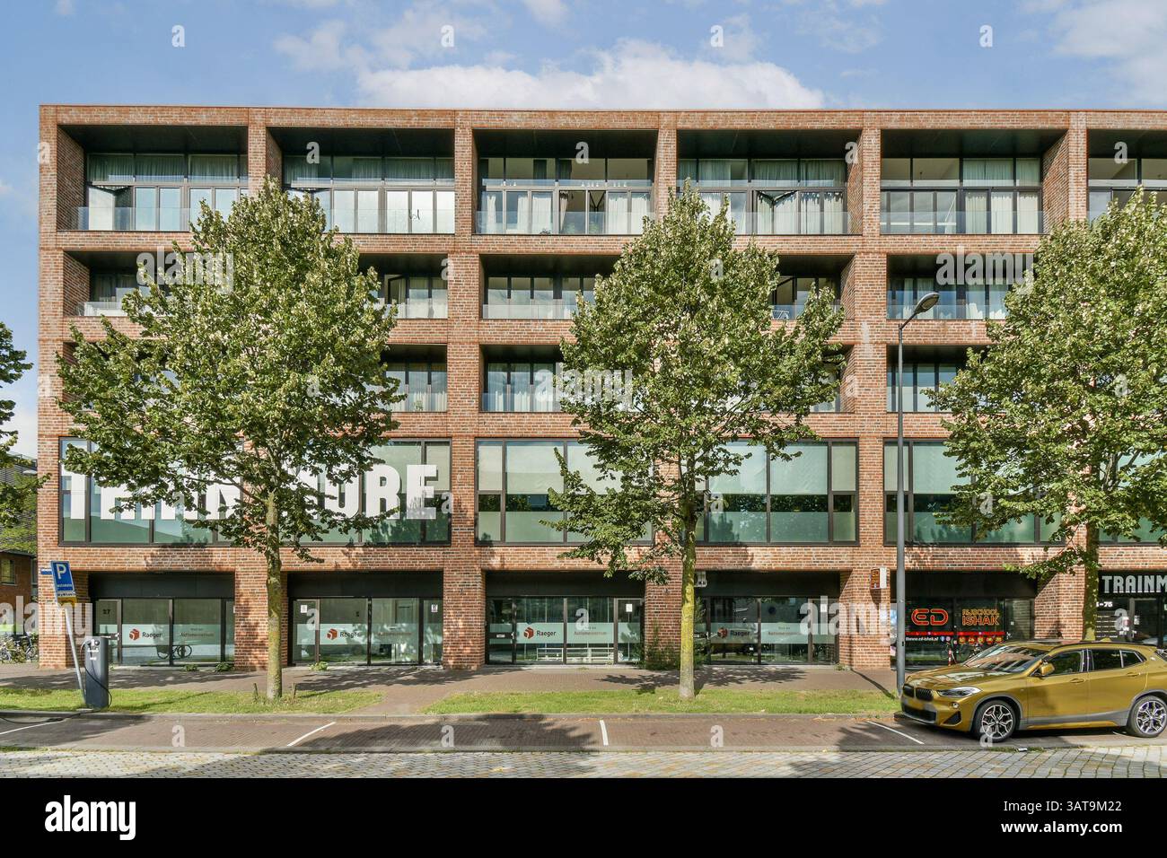 A contemporary brick structure features large glass windows and is ...