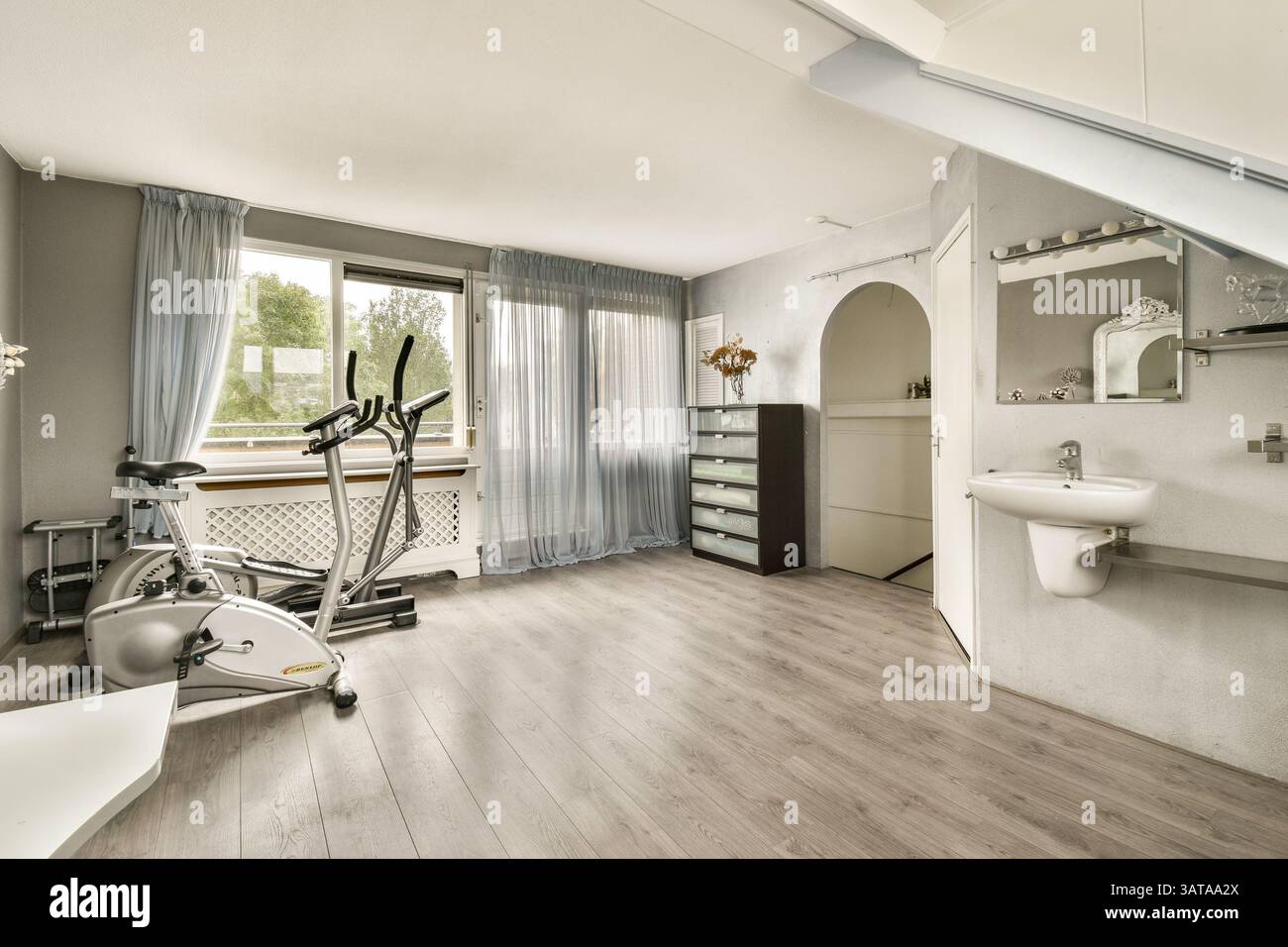 A contemporary home gym space featuring exercise equipment, natural ...