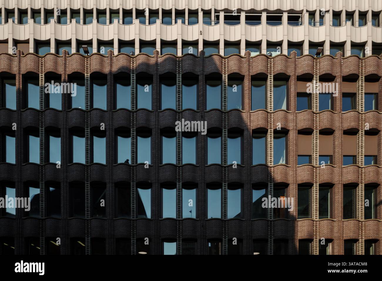 A building facade showcasing a rhythmic pattern of arched brick window ...
