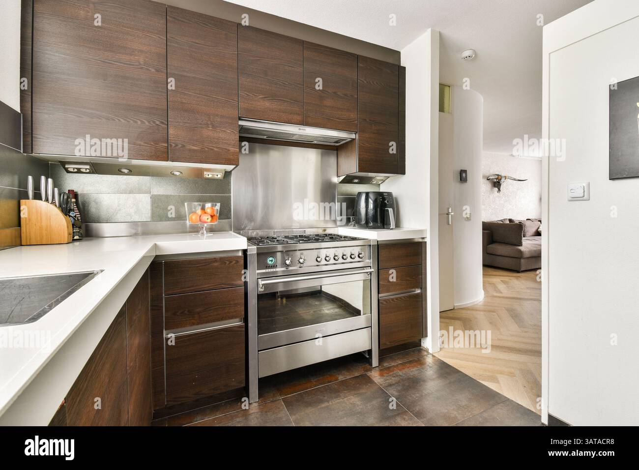 A sleek and contemporary kitchen design featuring dark wooden cabinets ...