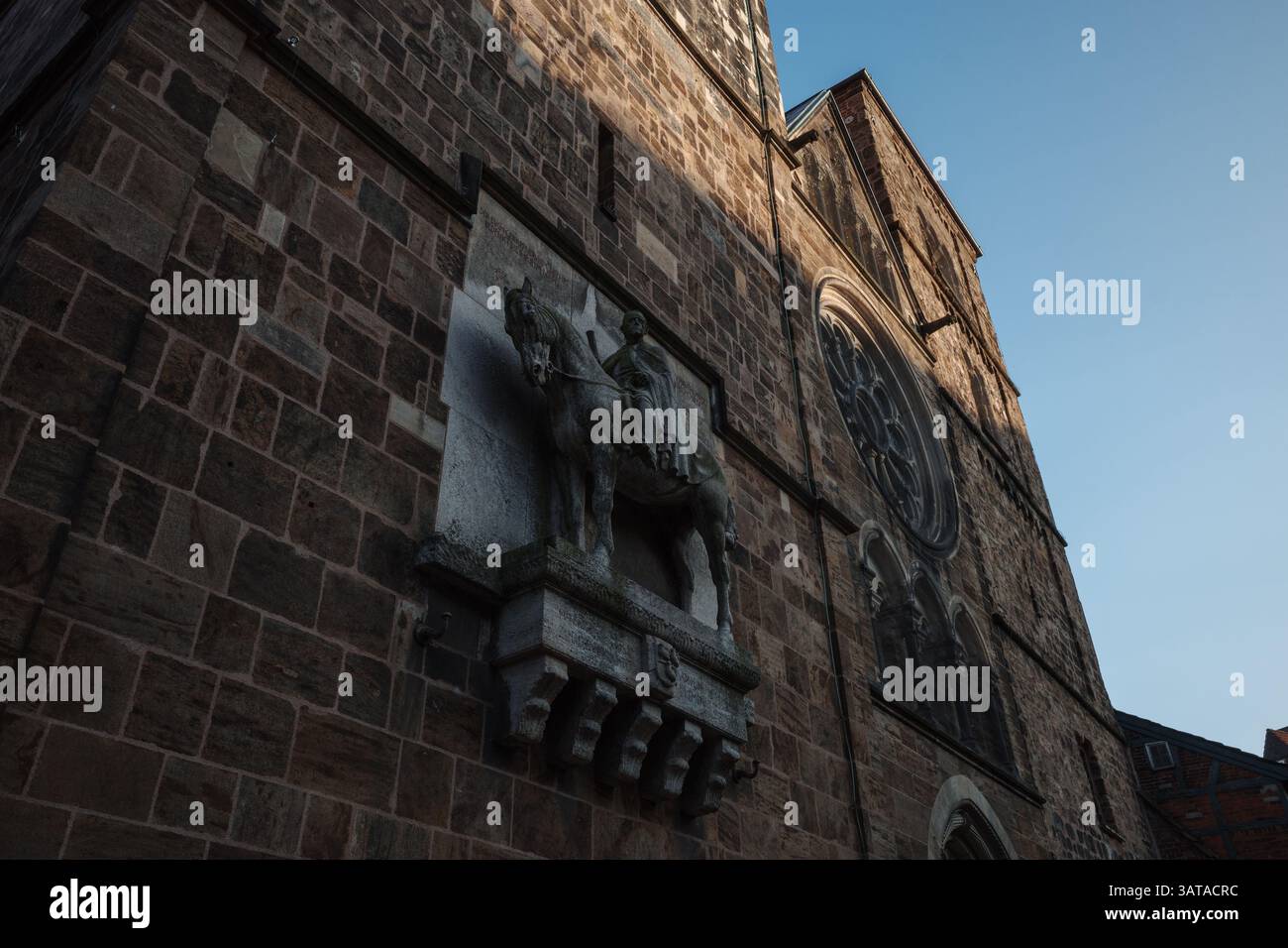 A historic stone cathedral wall featuring an equestrian statue of a ...
