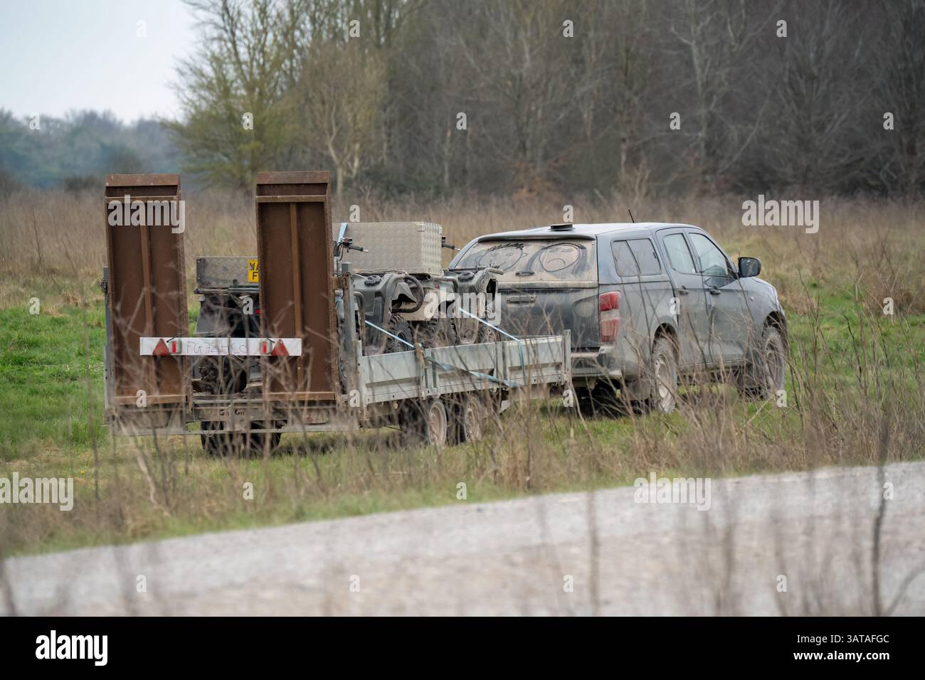 a pair of quad bikes on a trailer behind a toyota hilux invincible ...