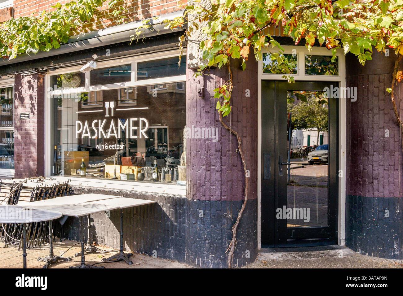 A quaint cafe exterior featuring outdoor seating amidst lush greenery ...