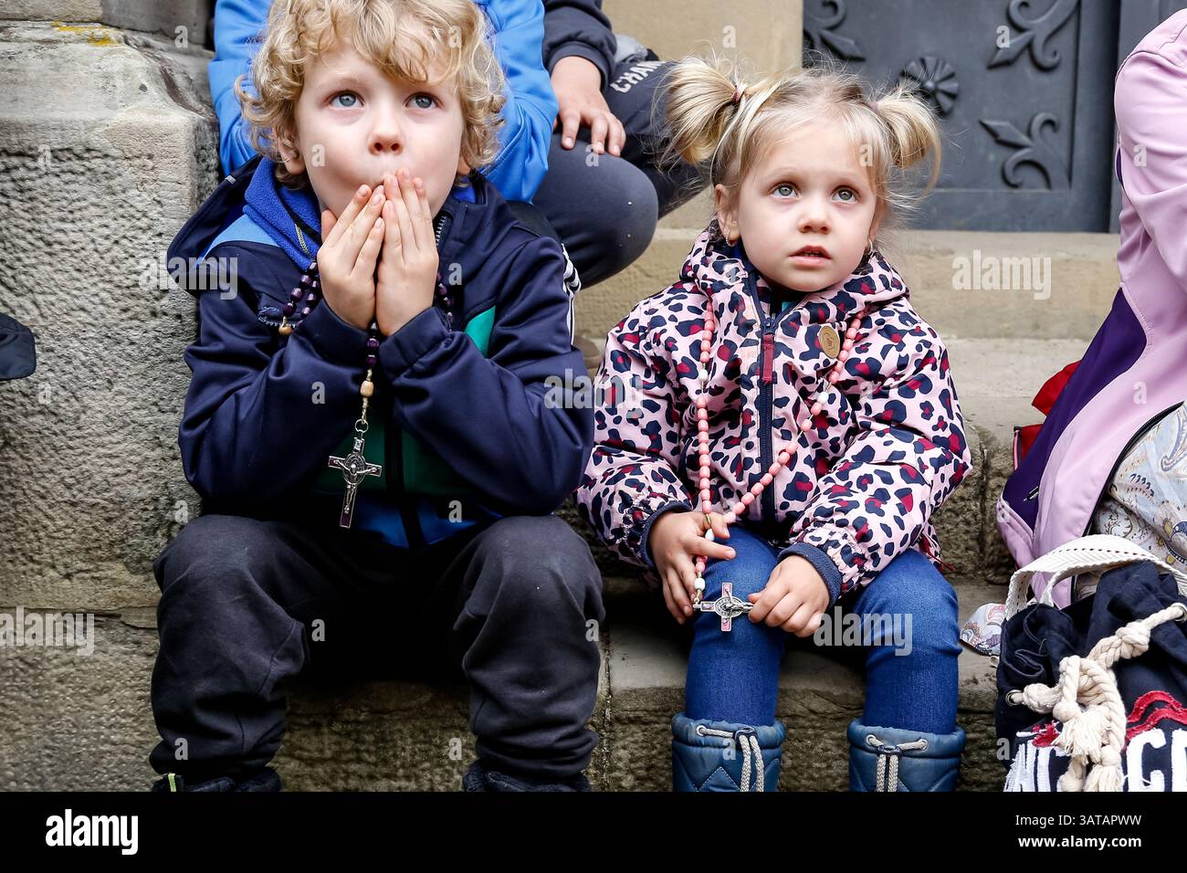 Children with crosses on their necks attend the procession in the Way ...