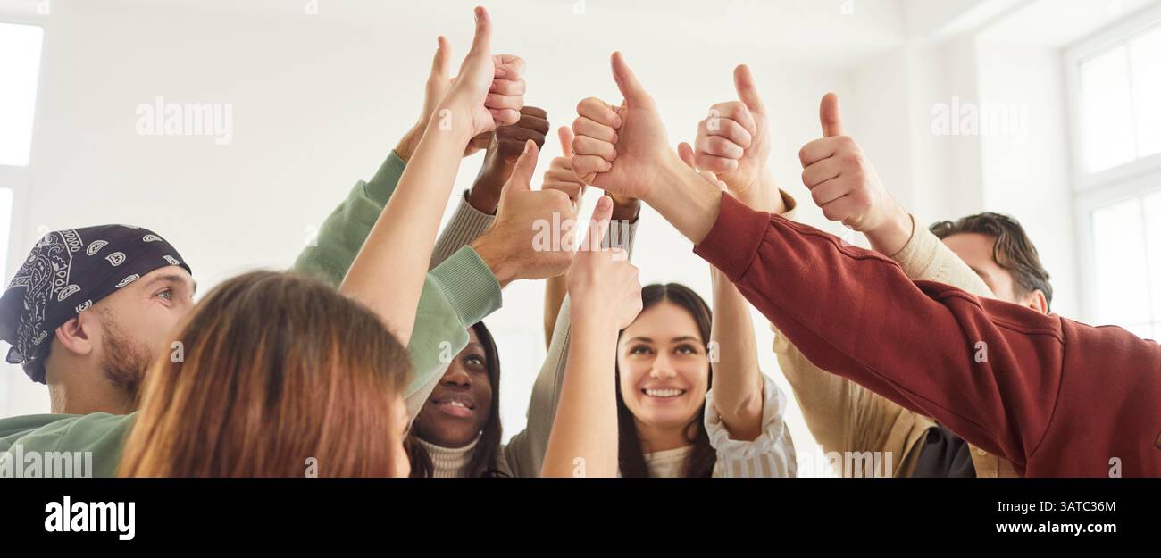 Diverse group of happy young people raising hands for thumbs up ...