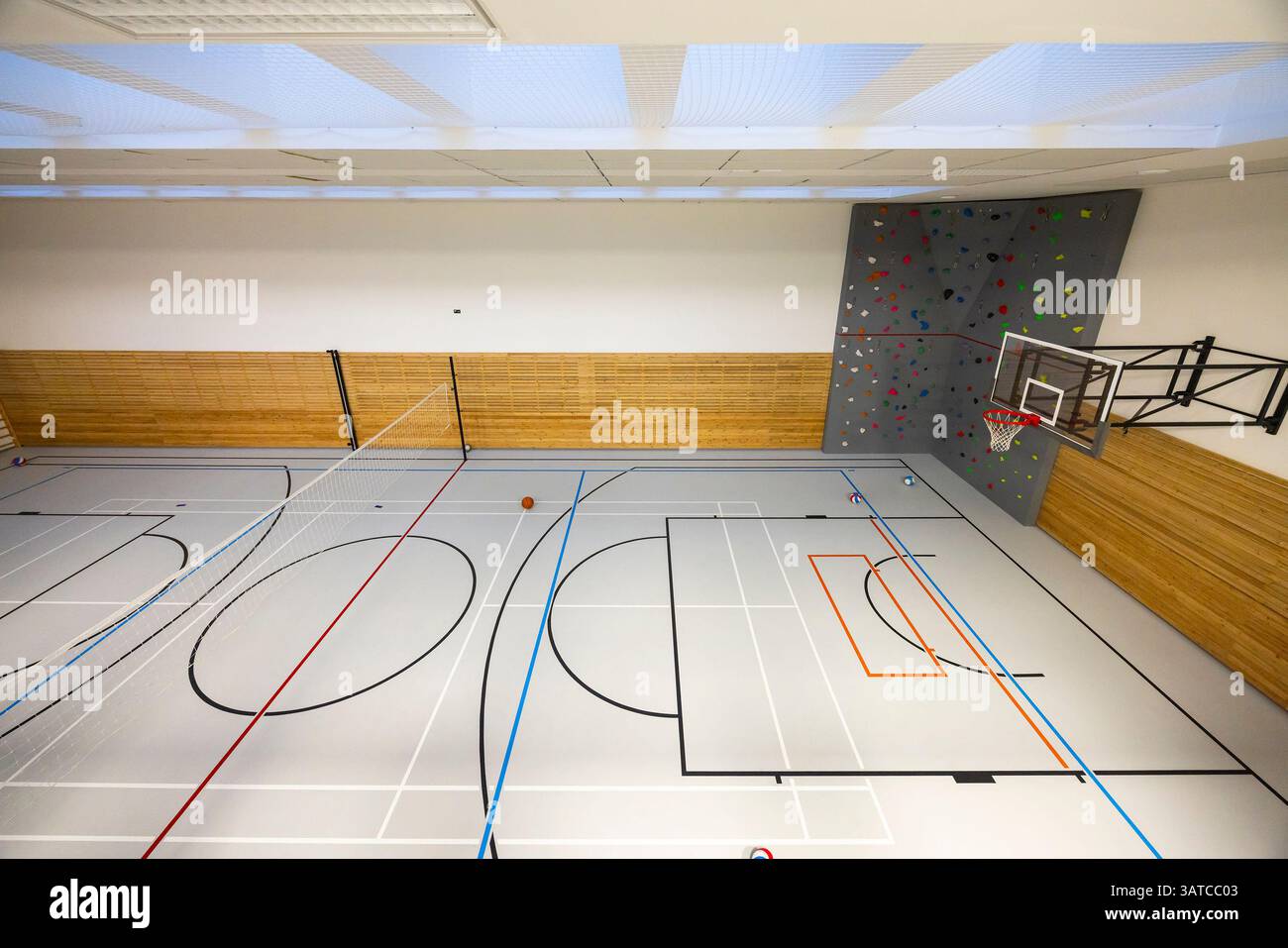 Modern sports hall with basketball hoop, volleyball net and climbing ...
