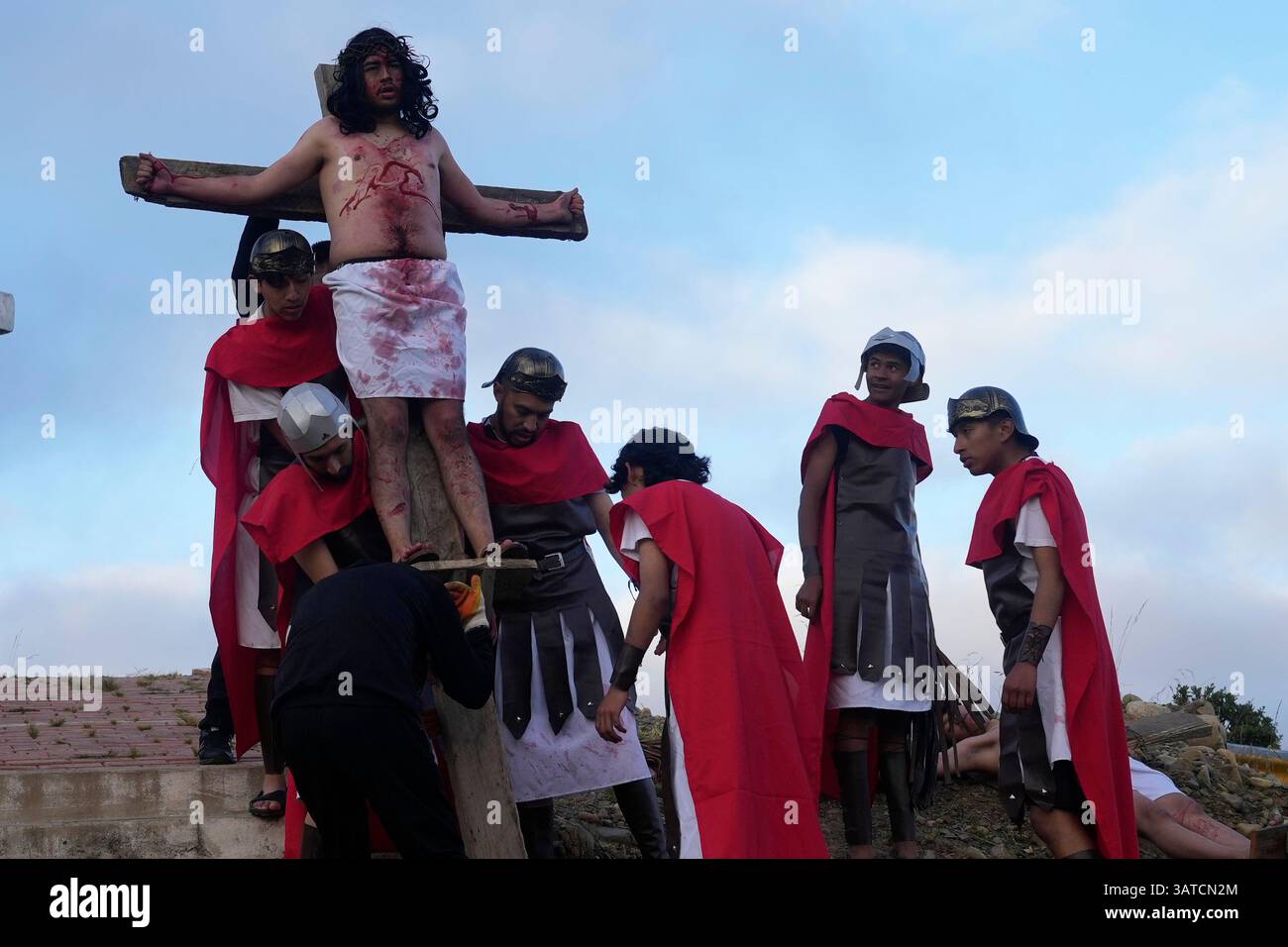 An actor playing the role of Jesus is lifted up to a cross during the ...