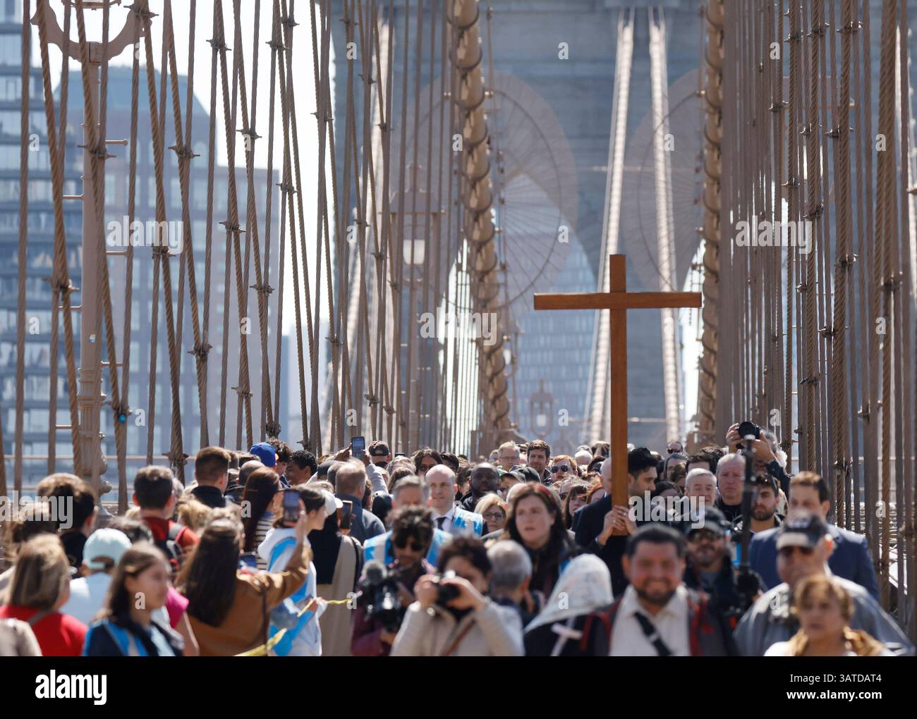 New York, United States. 18th Apr, 2025. A wooden cross leads a ...