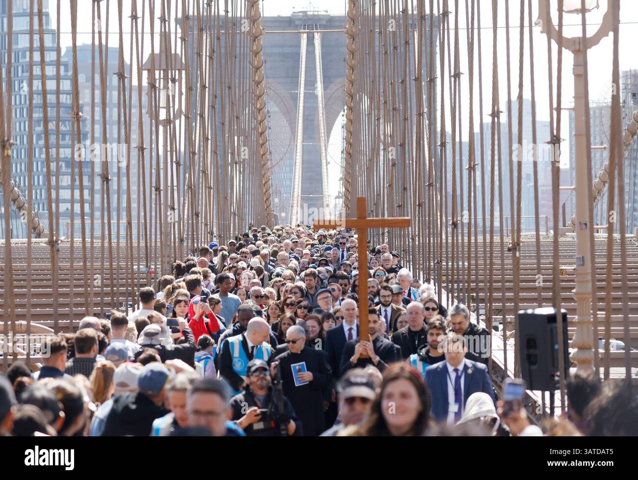 New York, United States. 18th Apr, 2025. A wooden cross leads a ...