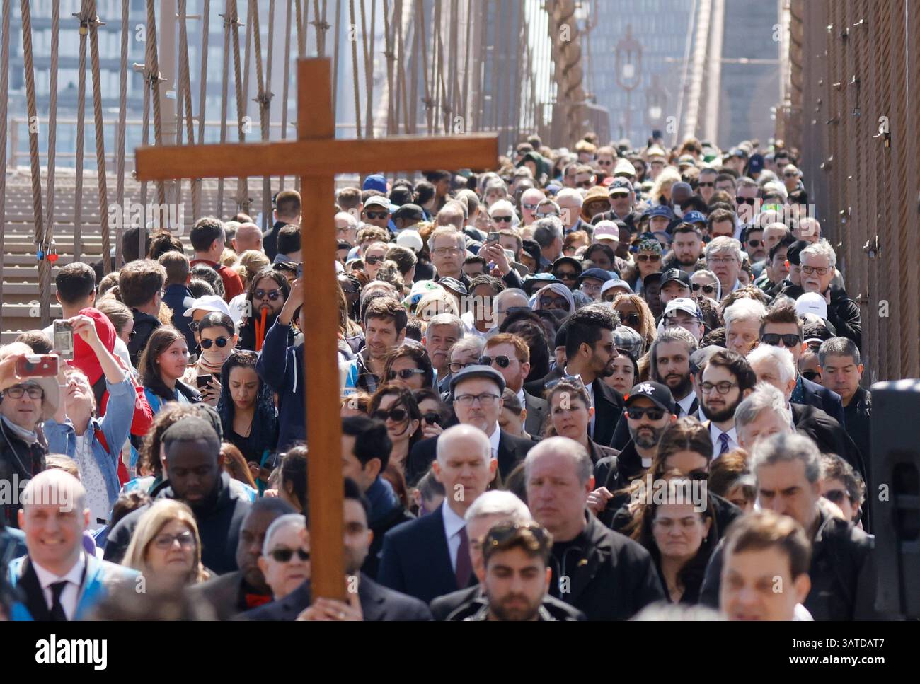 New York, United States. 18th Apr, 2025. A wooden cross leads a ...