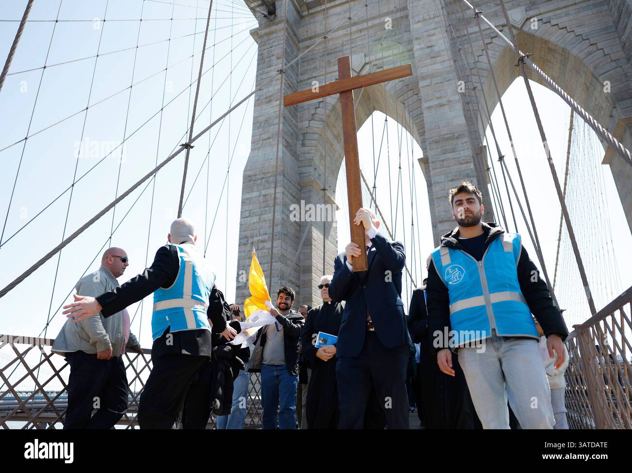 New York, United States. 18th Apr, 2025. A wooden cross leads a ...