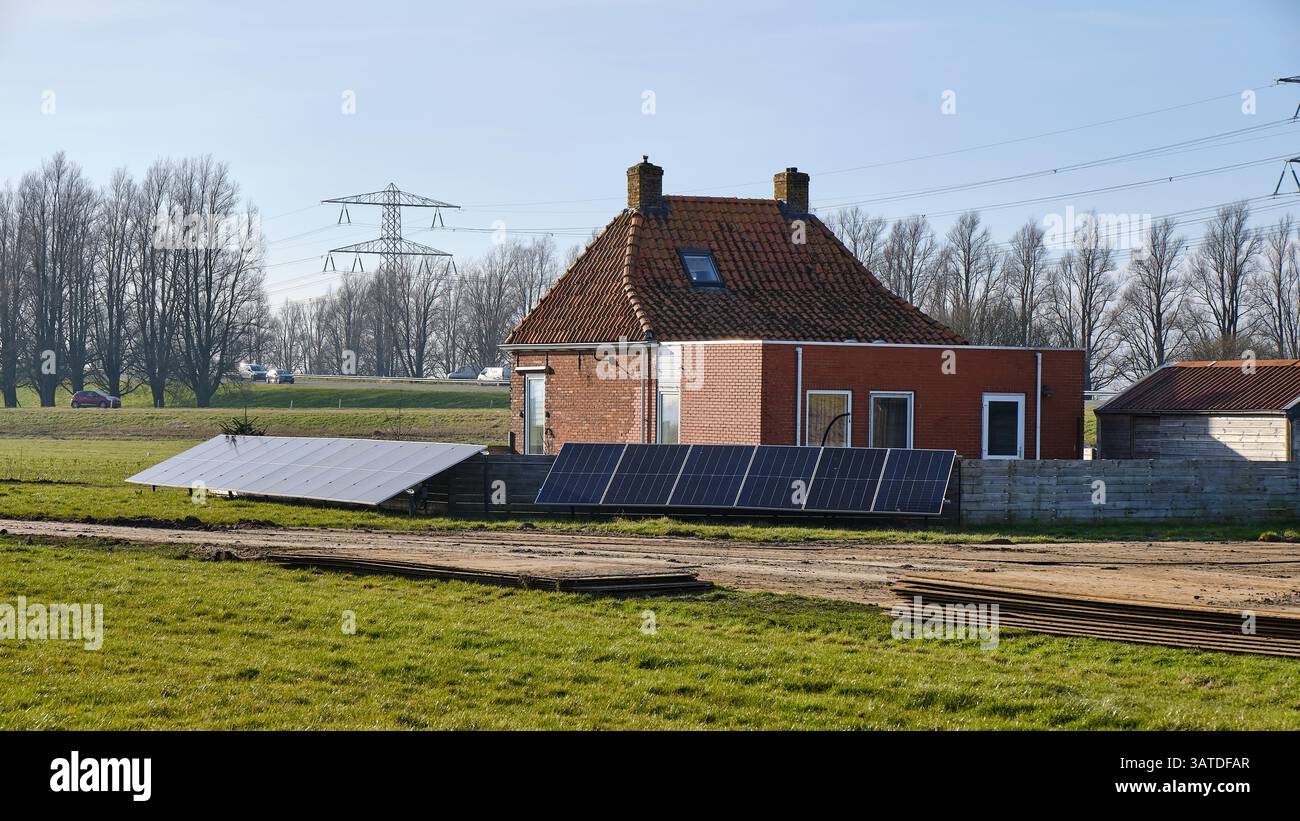March 5, 2025 - Warga-Netherlands: Small rural house near windmill with ...