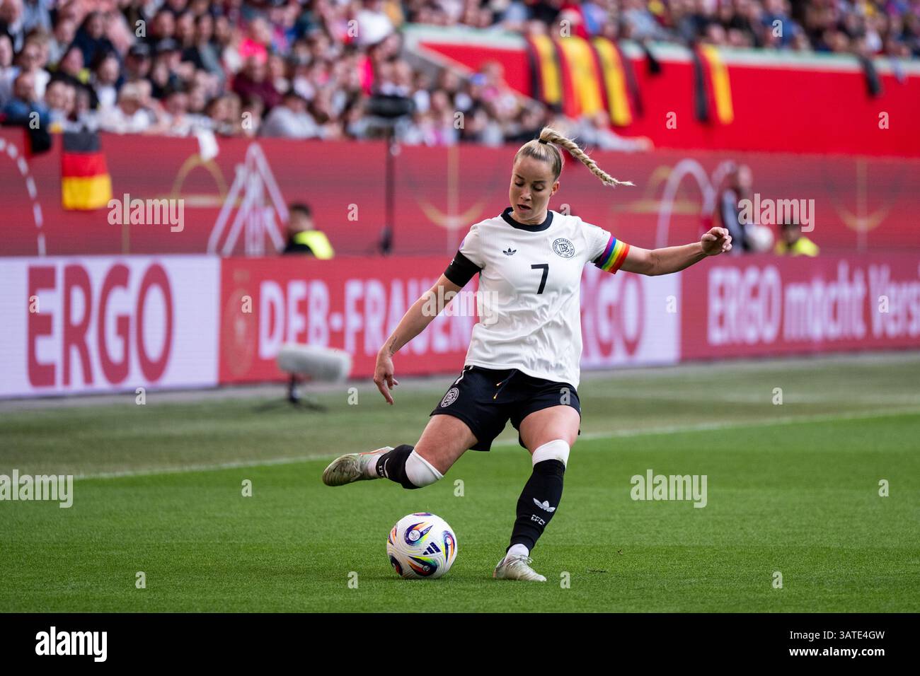 Giulia Gwinn (Deutschland, #07) am Ball, dahinter Fans mit Fahnen ...