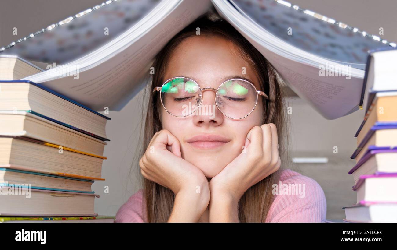 Relaxed Student Resting Amidst Books. A young student wearing glasses ...