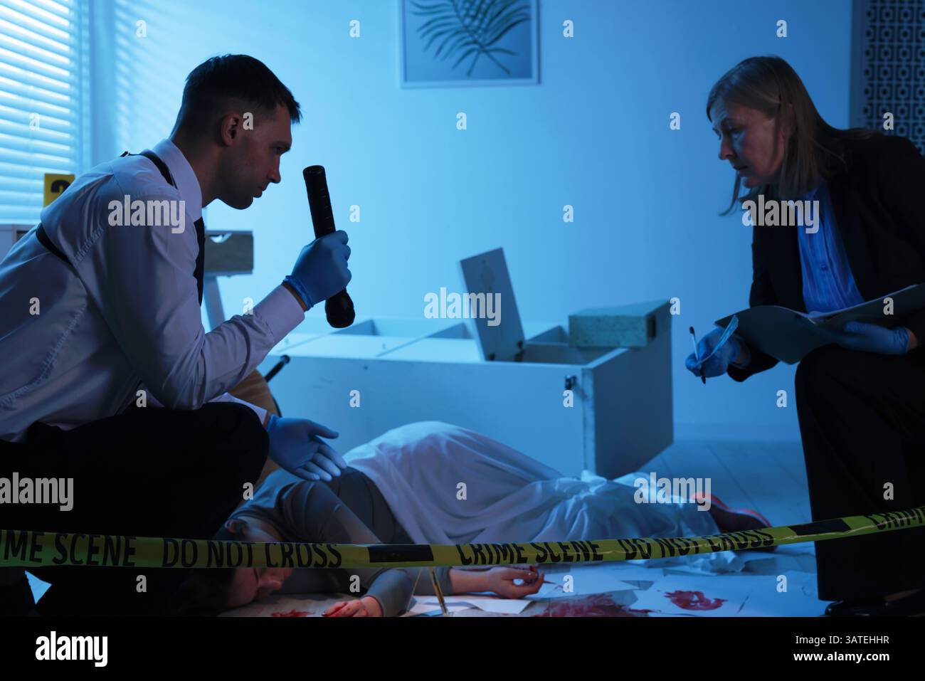 Forensic experts working at crime scene with dead woman's body indoors ...