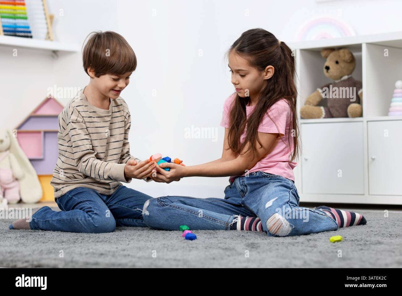 Children playing with balancing stones on floor indoors Stock Photo - Alamy