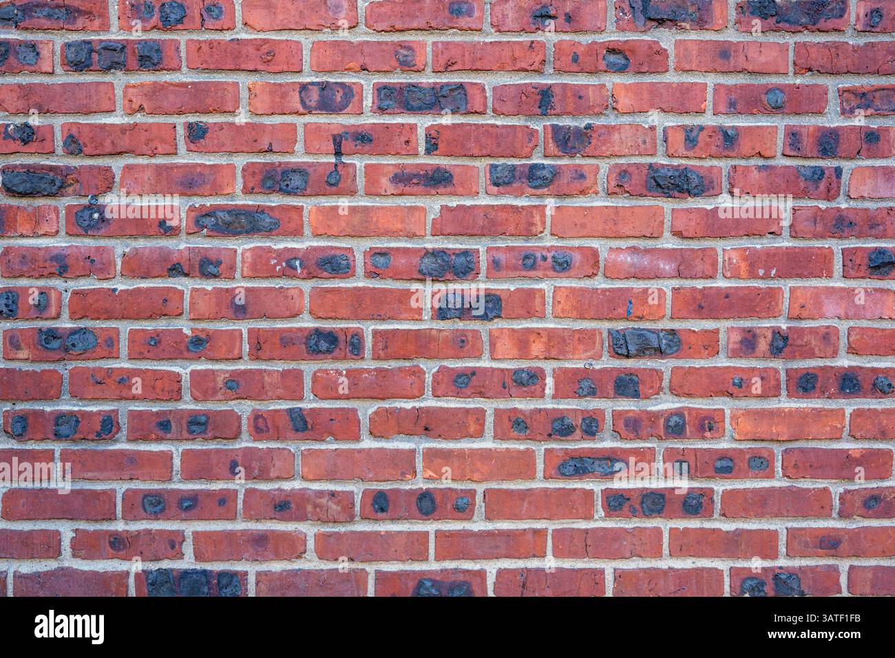 Background from a red brick wall with burnt black spots Stock Photo - Alamy
