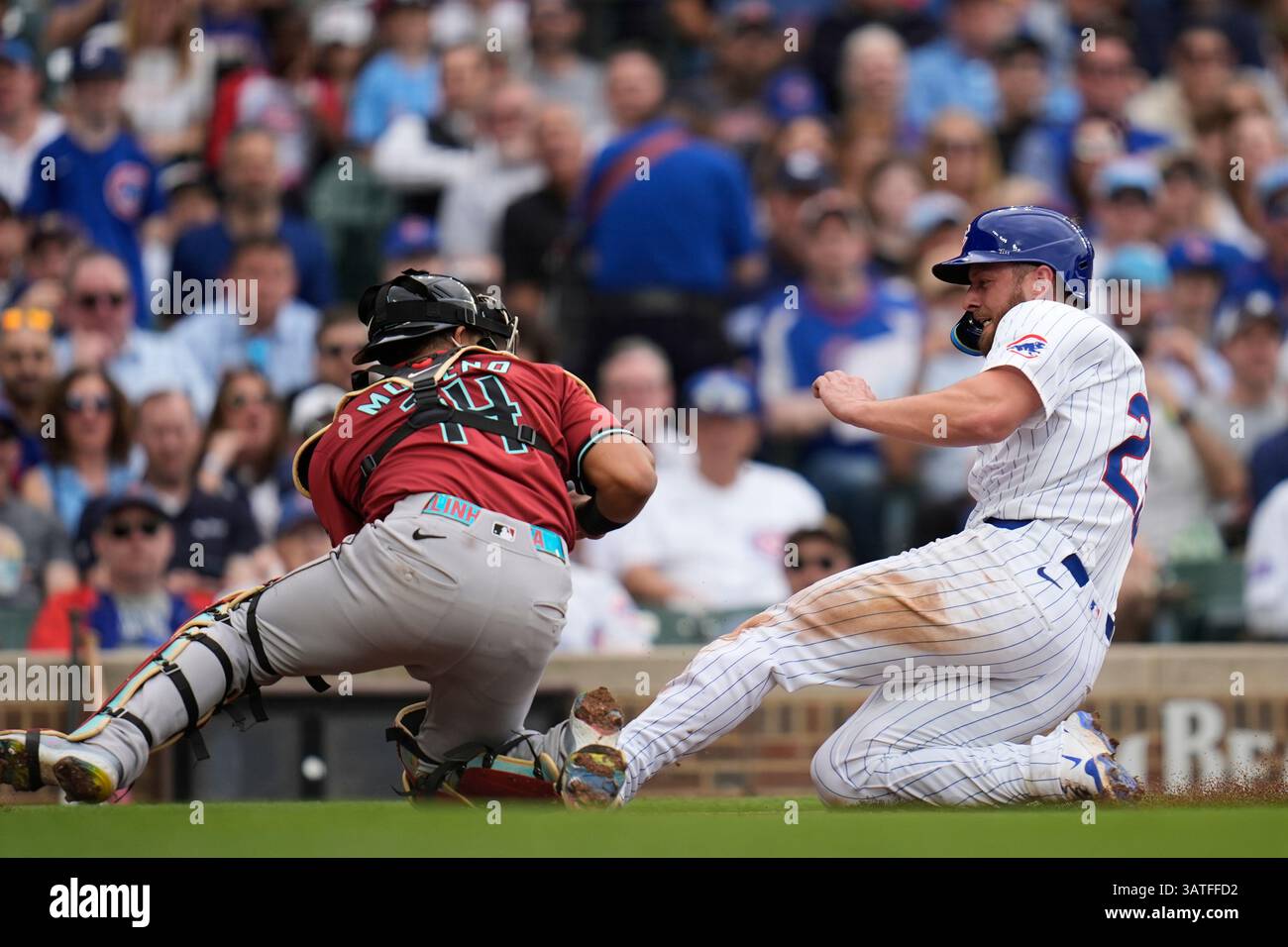 Chicago Cubs' Michael Busch, right, is tagged out by Arizona ...