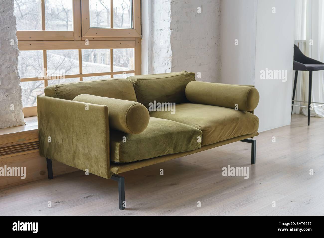 Cozy green khaki velours couch in bright and airy living space with ...