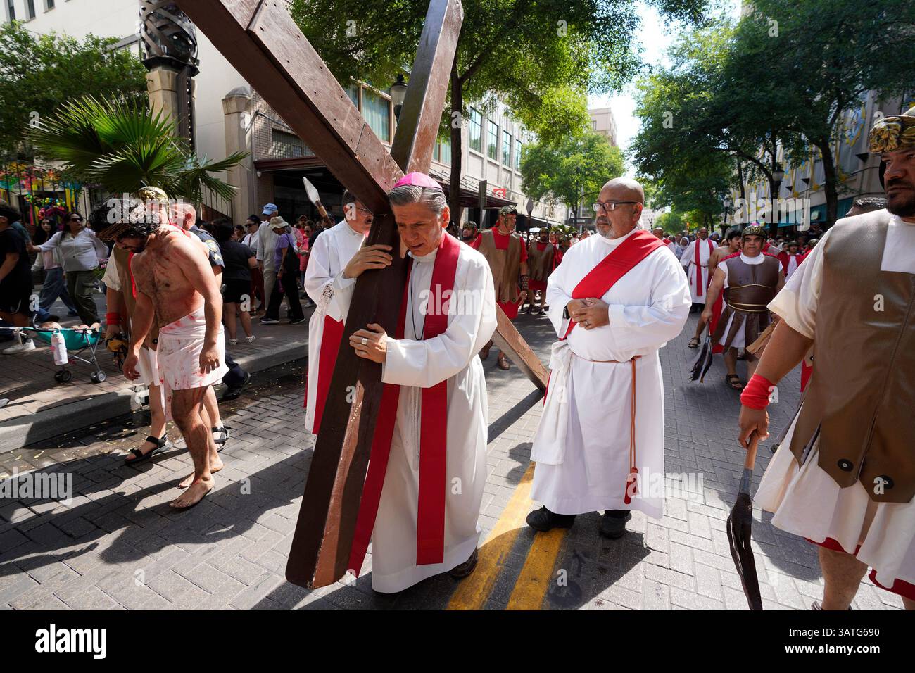 Archbishop Gustavo Garcia-Siller carries the cross as re-enactors and clergy perform the Good ...