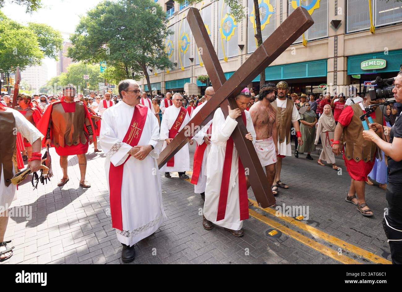 Archbishop Gustavo Garcia-Siller carries the cross as re-enactors and clergy perform the Good ...