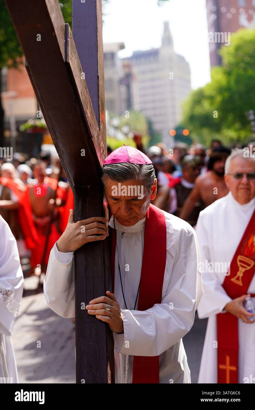 Archbishop Gustavo Garcia-Siller carries the cross as re-enactors and clergy perform the Good ...