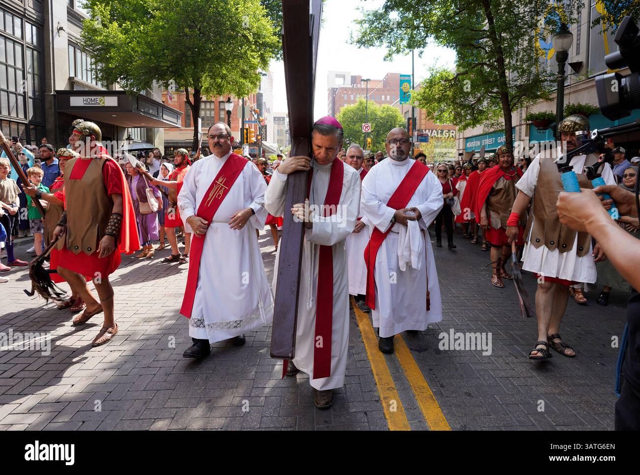 Archbishop Gustavo Garcia-Siller carries the cross as re-enactors and clergy perform the Good ...