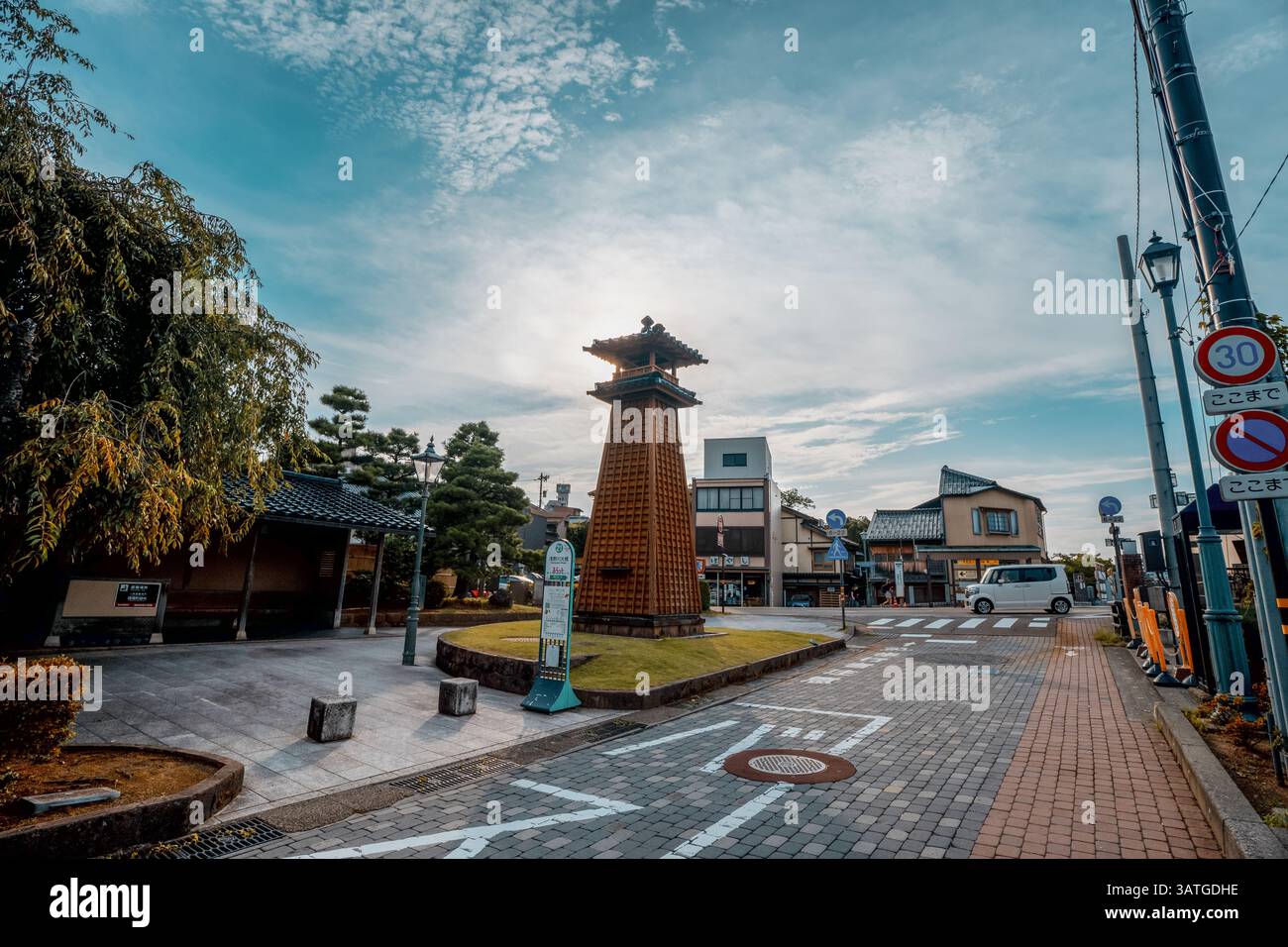 A peaceful street scene featuring a traditional wooden tower ...