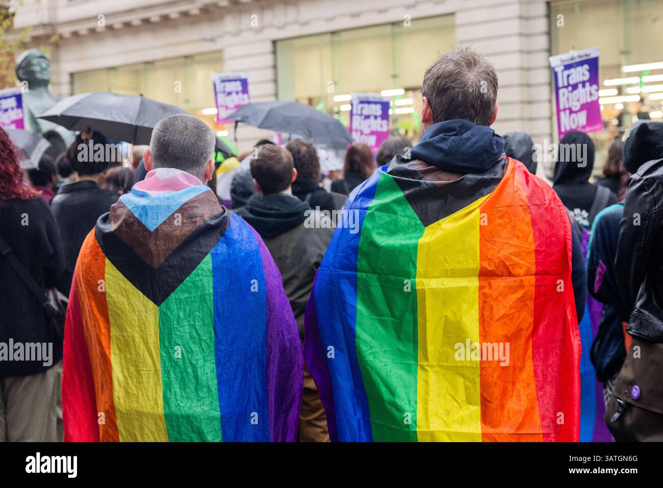 Leeds, UK. 18 APR, 2025. at Two people wear LGBT flags among "Trans ...
