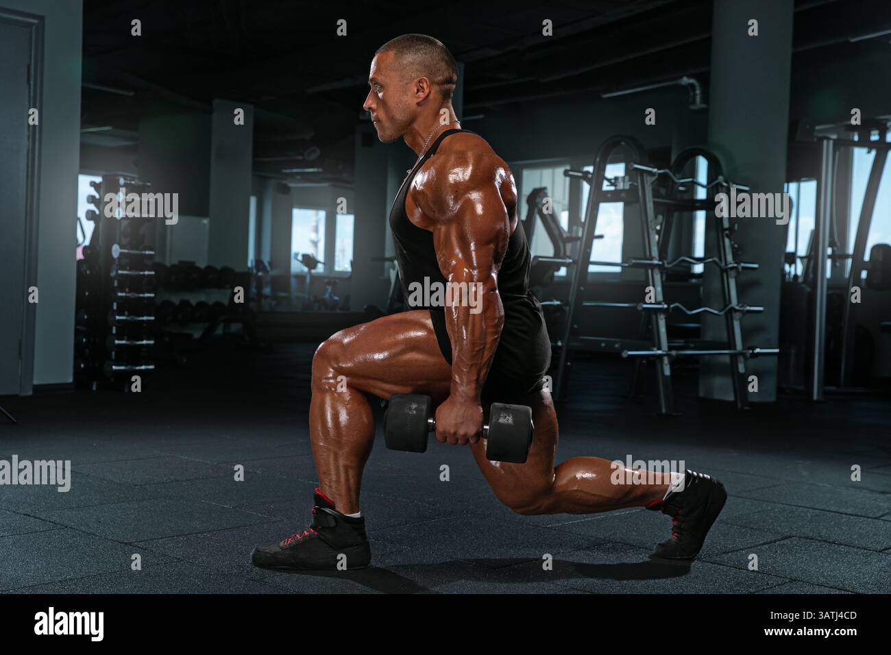 dedicated athlete executes a lunge with dumbbells in a modern gym ...
