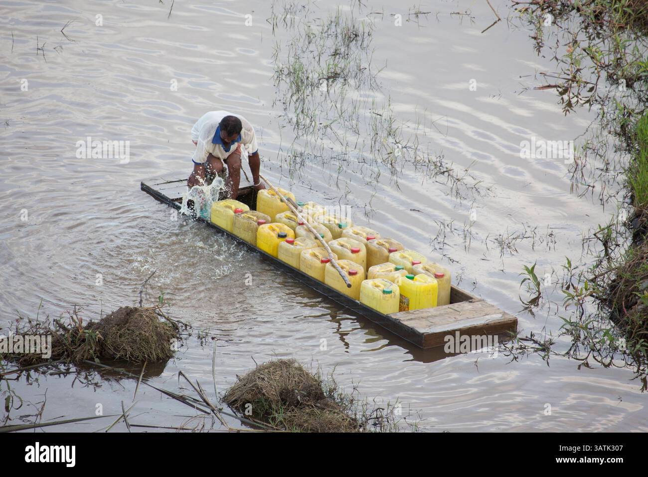 Water management in Madagascar A man bails water from a boat after ...