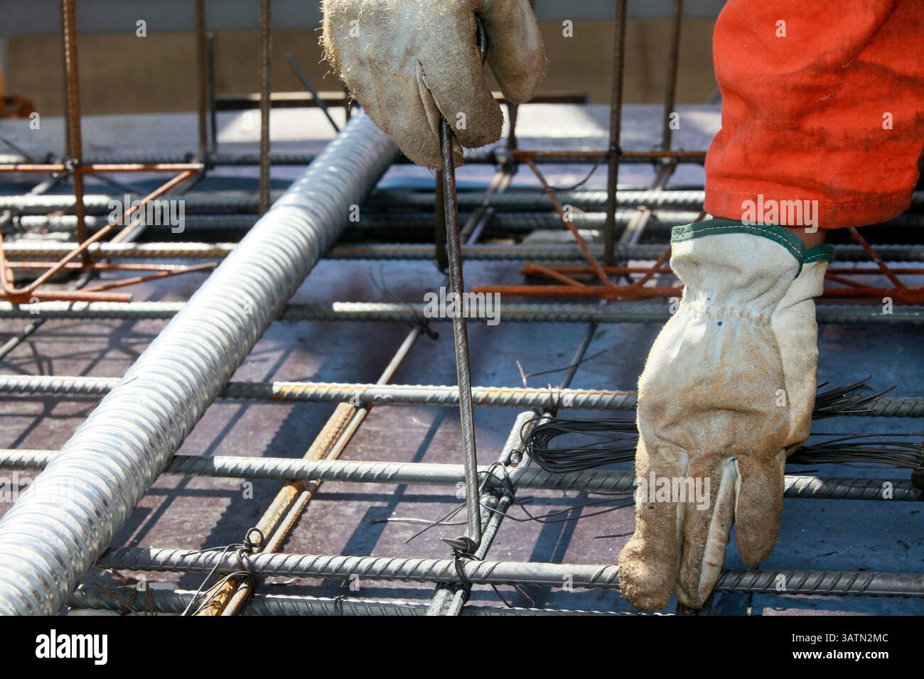 detail of worker tying steel rebar on road construction on countryside ...