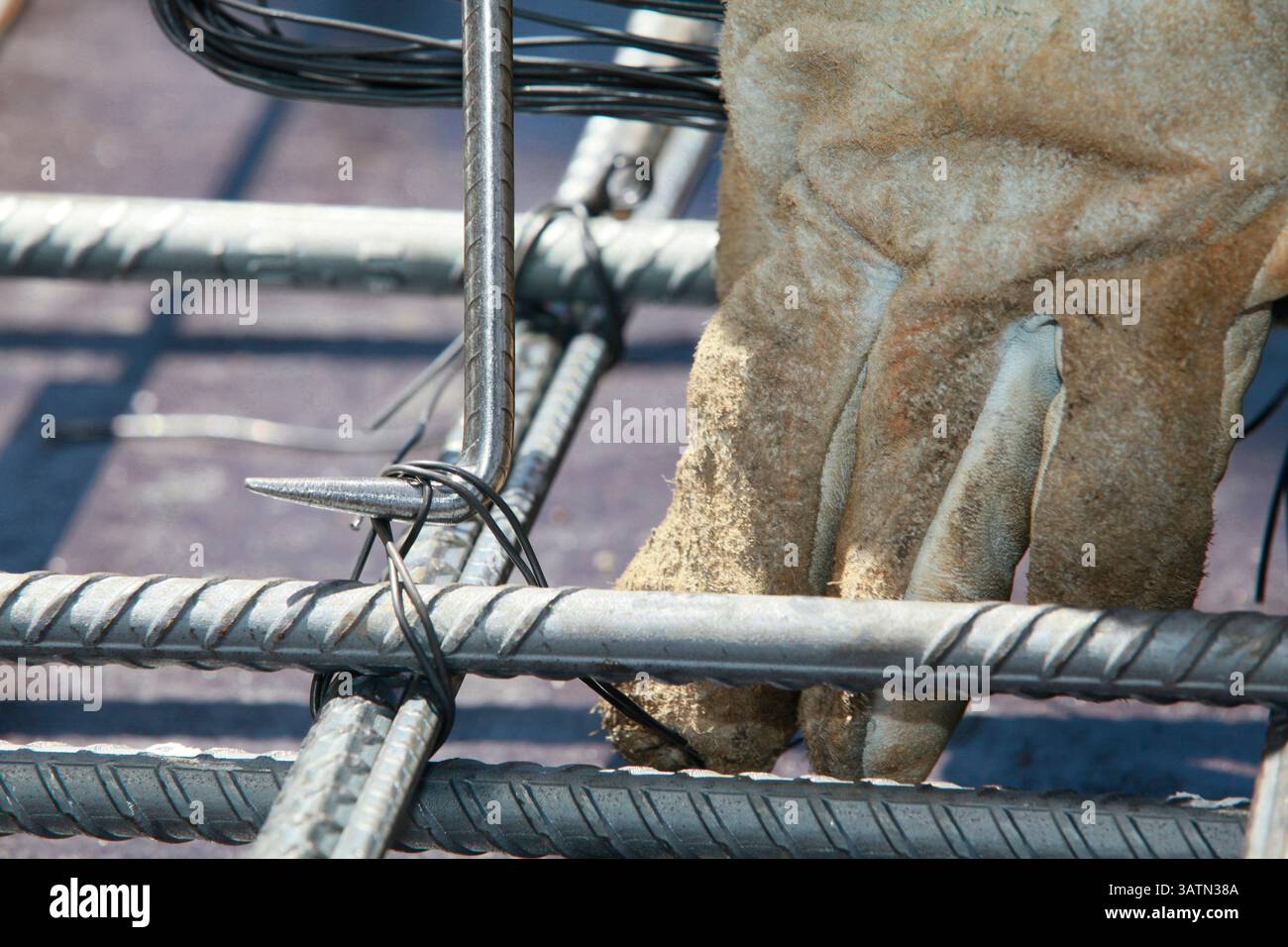 detail of worker tying steel rebar on road construction on countryside ...