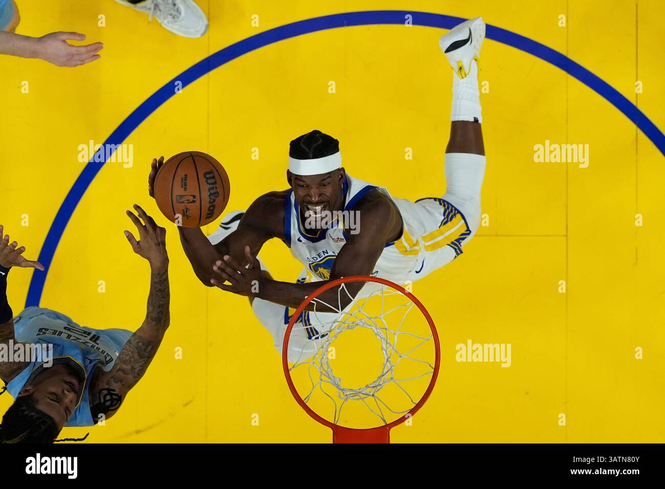 Golden State Warriors forward Jimmy Butler III, middle, shoots against the Memphis Grizzlies ...