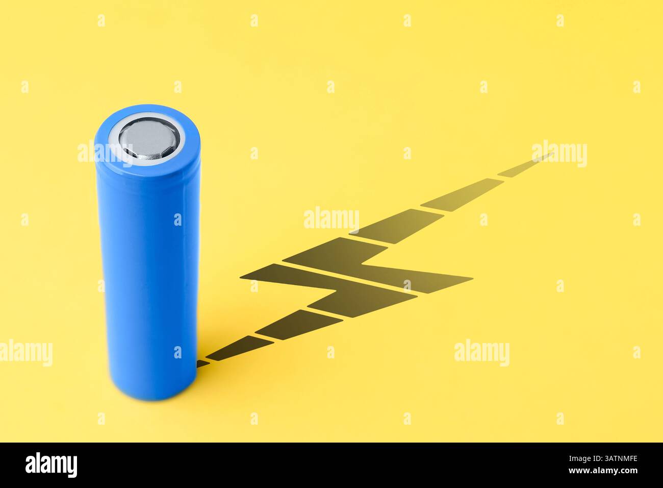 Alkaline battery with shadow in shape of lightning on yellow background ...