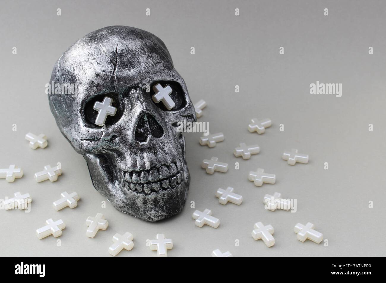 Faith beyond death, skull surrounded by crosses Stock Photo - Alamy
