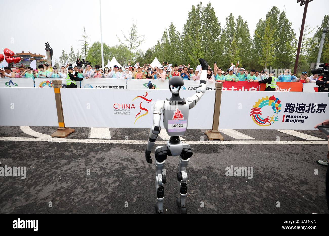 Beijing, China. 19th Apr, 2025. Participants waves to a robotic ...