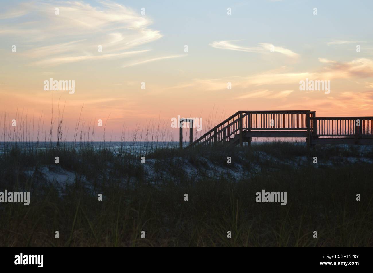Boardwalk at sunset over sand dunes on Gulf of Mexico beach in Destin ...