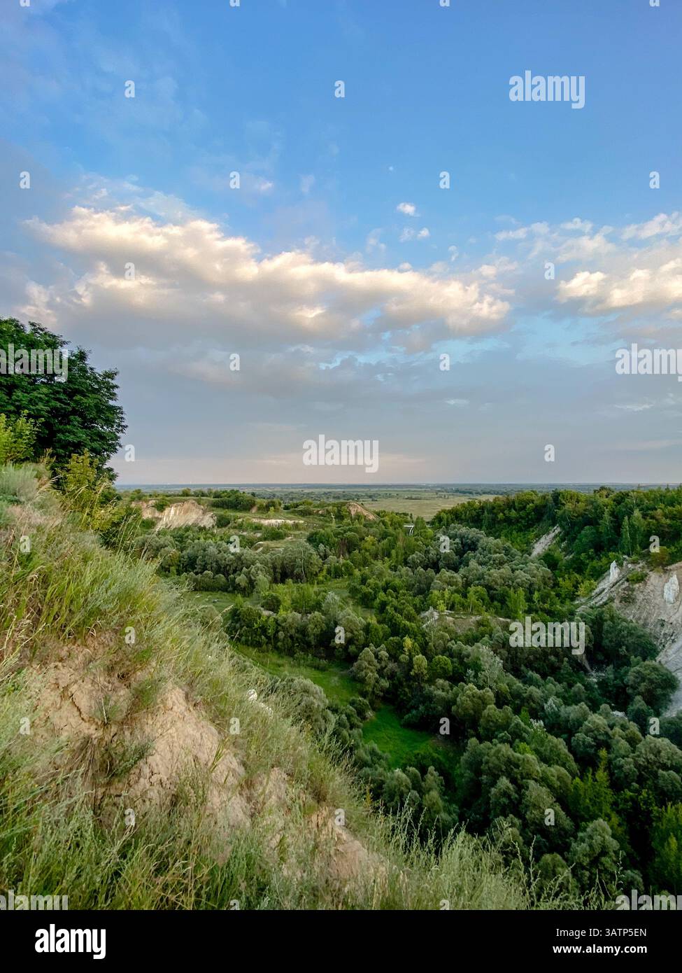 Green forests and winding path in rural landscape with dramatic sunset ...
