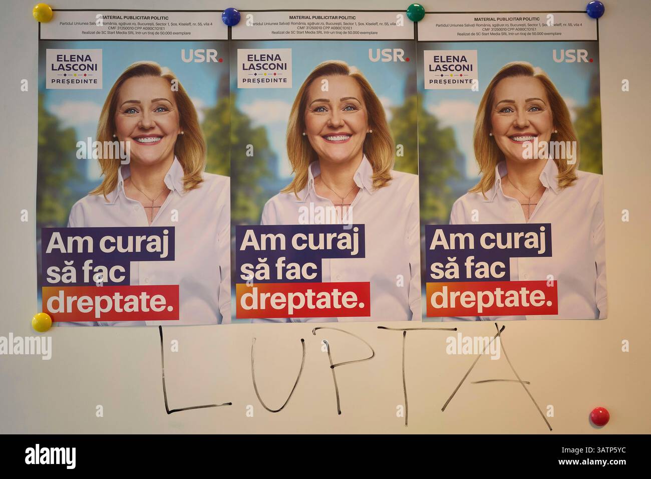 The word "Fight" is written on a board below posters of Elena Lasconi ...