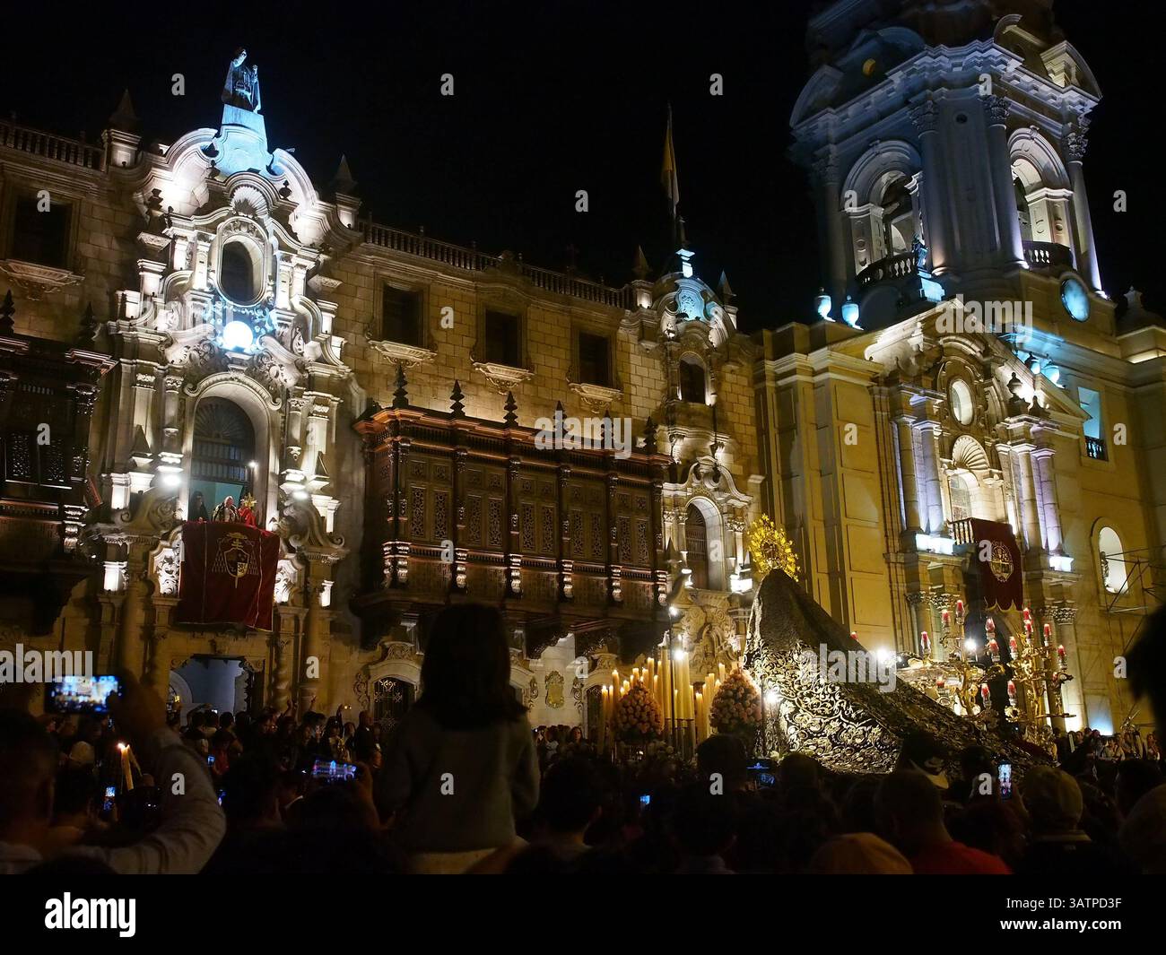 Catholic devotees, hooded, carrying on a religious procession at eve on ...