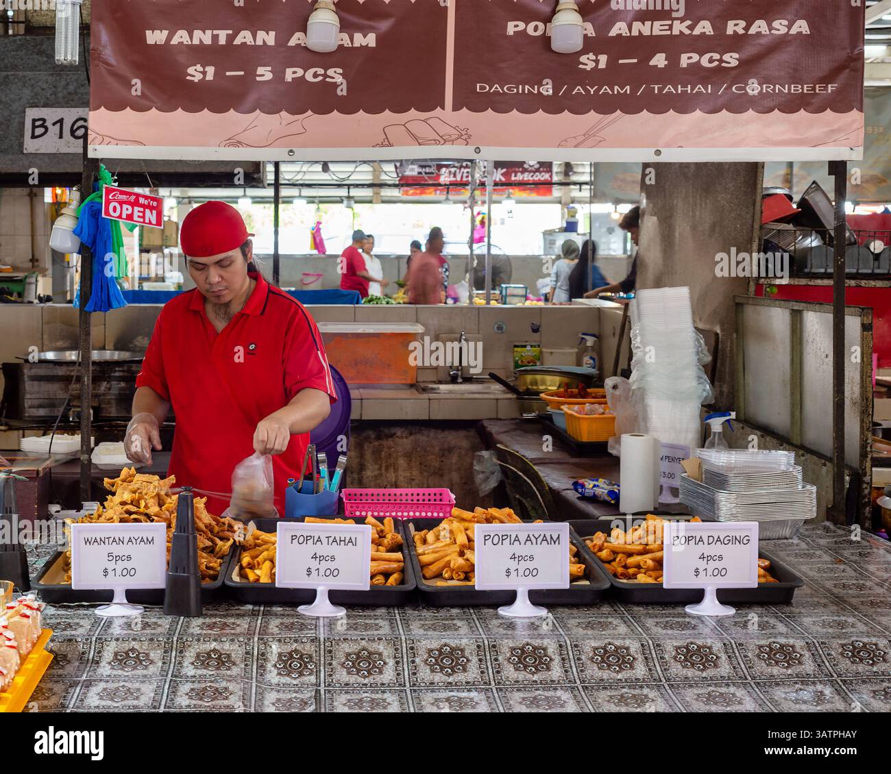 Bandar Seri Begawan, Brunei - Feb. 26, 2025: A vendor packing fried ...
